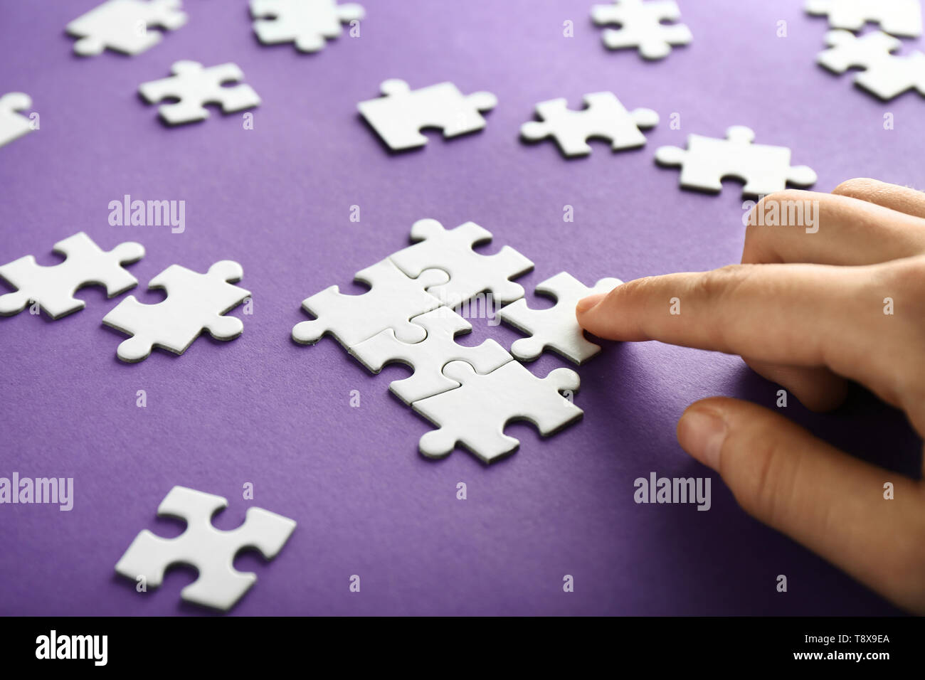 Hand of woman doing puzzle on color background, closeup Stock Photo - Alamy