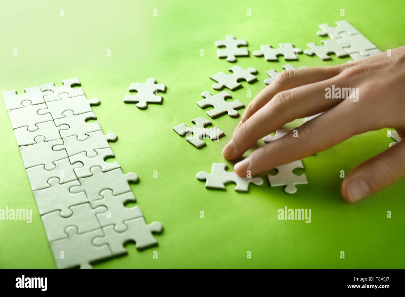 Hand of woman doing puzzle on color background, closeup Stock Photo - Alamy