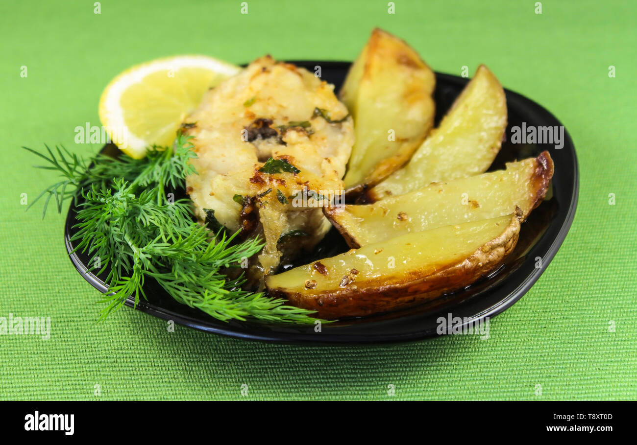 Still-life with fried fish and baked potatoes on a platter Stock Photo ...