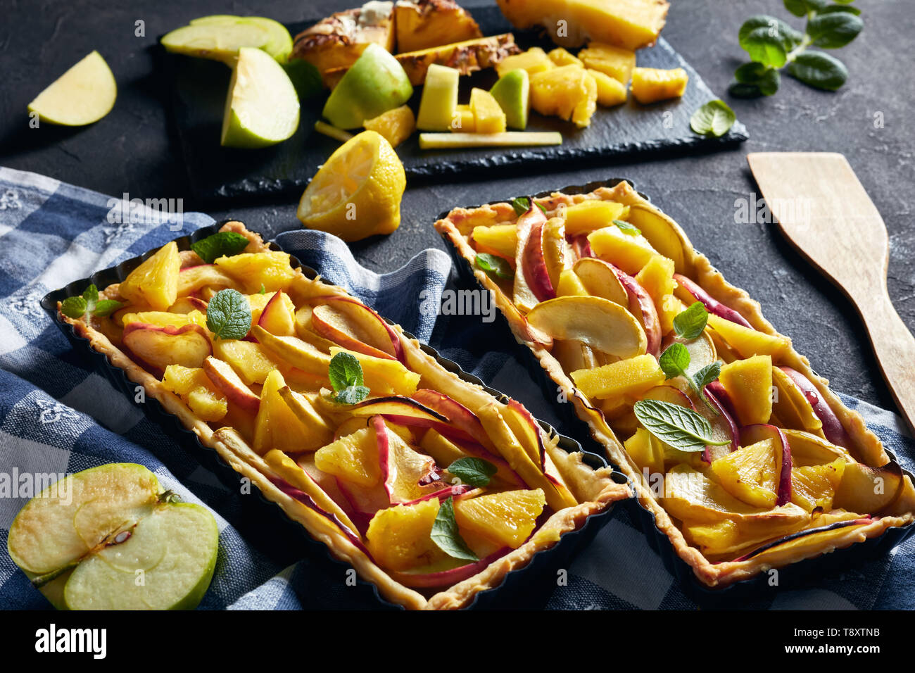 french pineapple and apple sweet tarts in rectangular tart pans on a ...