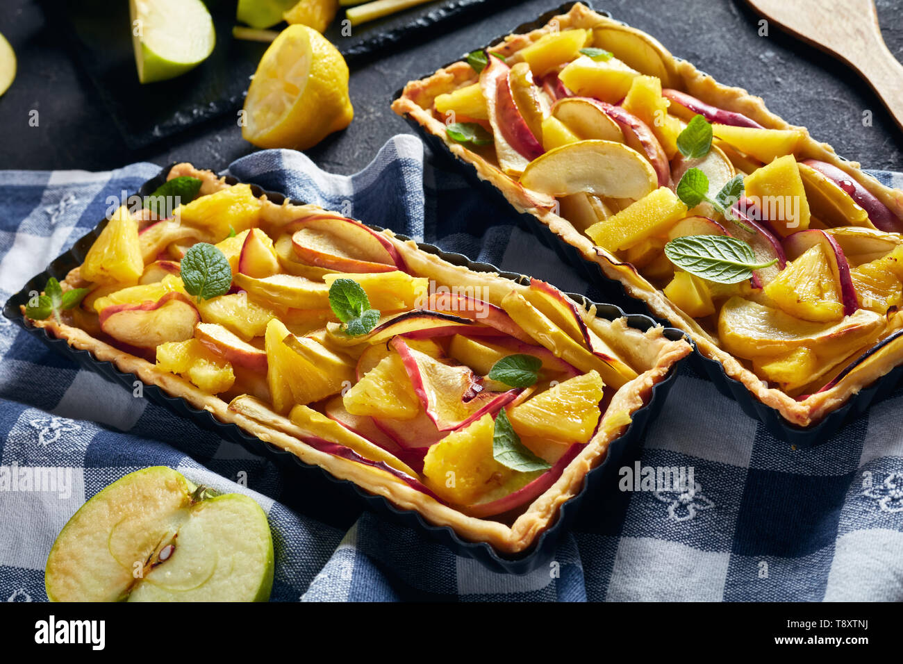 french pineapple and apple sweet open tarts in rectangular tart pans on ...