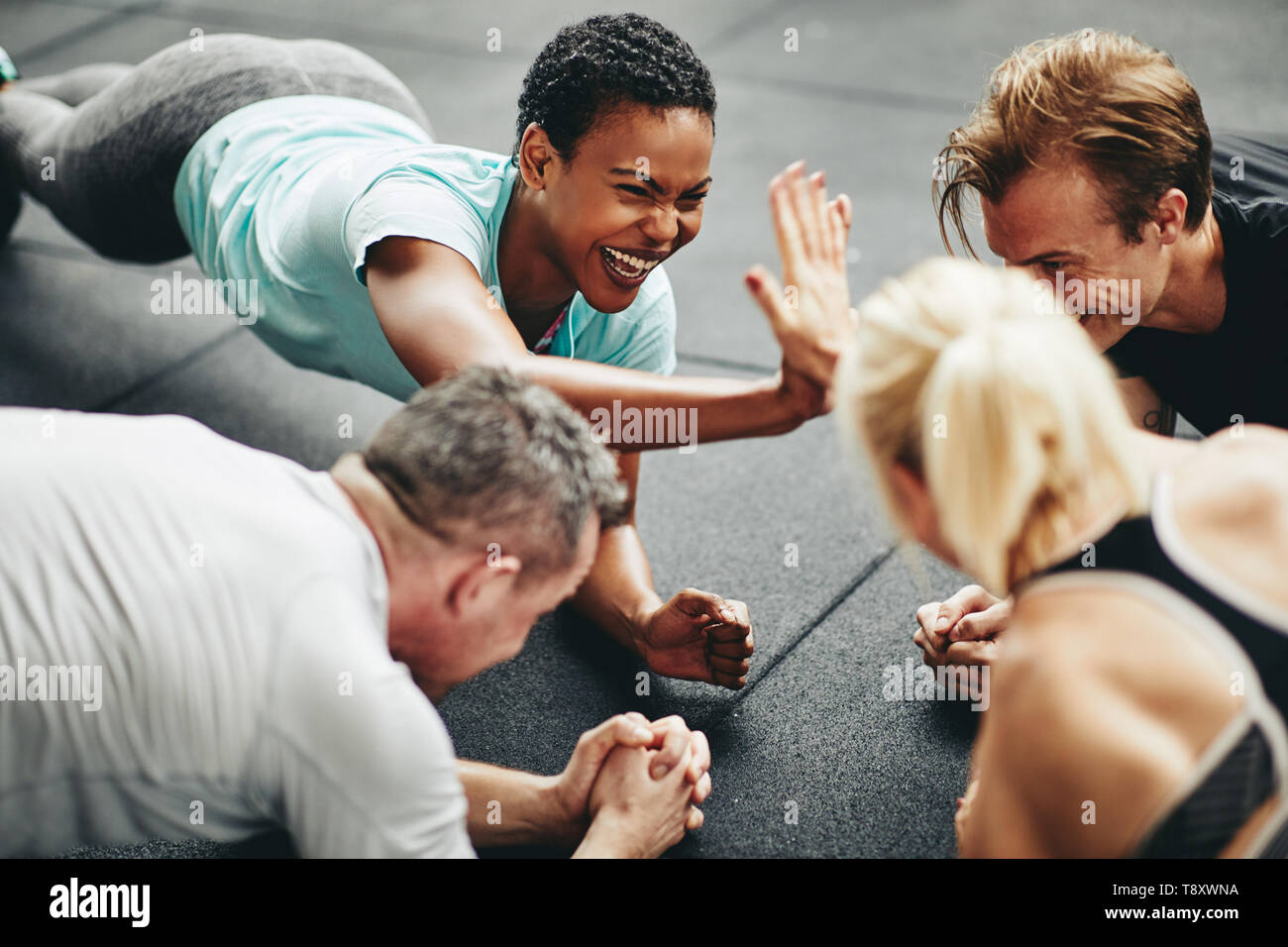 Two fit young women in sportswear laughing and high fiving together ...