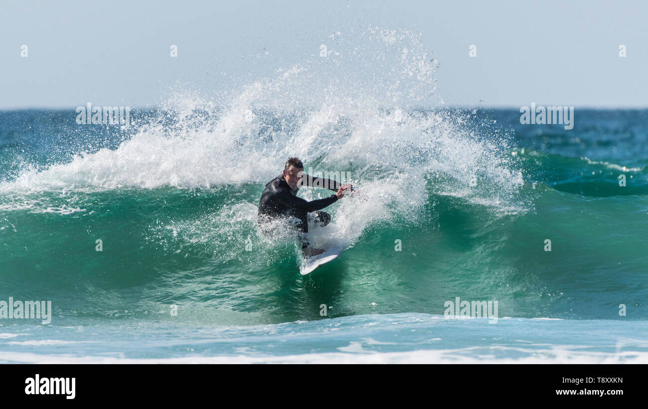 A panoramic image of surfing action as a surfer performs a snap trick ...