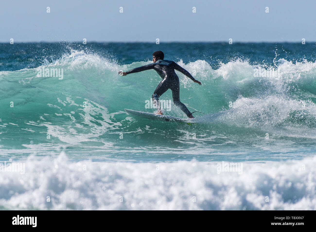 Spectacular surfing action as a surfer rides a wave in a jade coloured ...