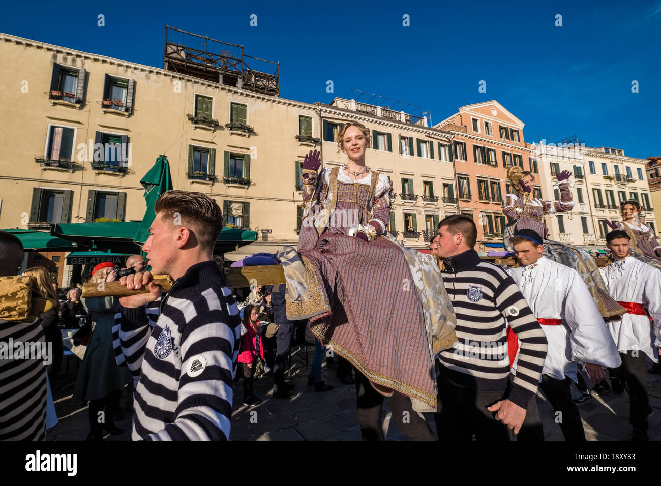 A beautiful young women is getting carried by young men at the ...