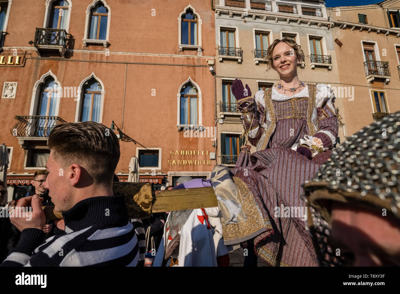 A beautiful young women is getting carried by young men at the ...