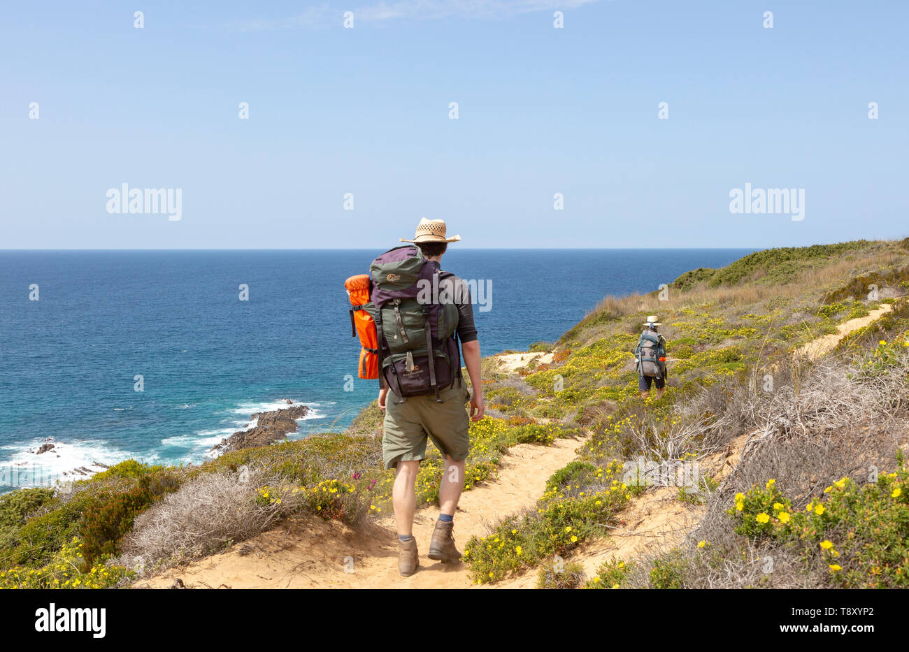 Two people walking the cliff top coastal long distance footpath trail ...