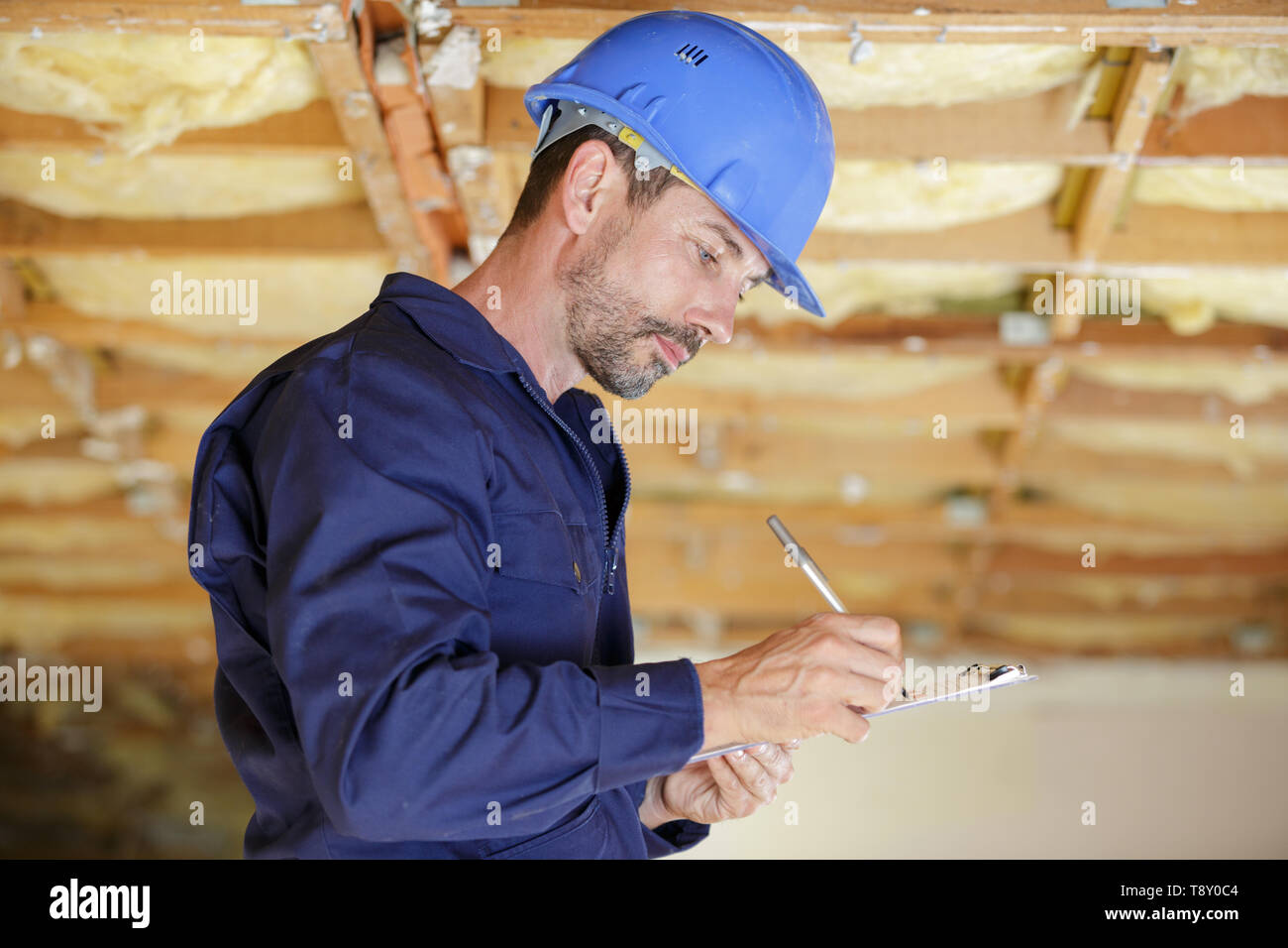 male engineer writing on clipboard at construction site Stock Photo - Alamy