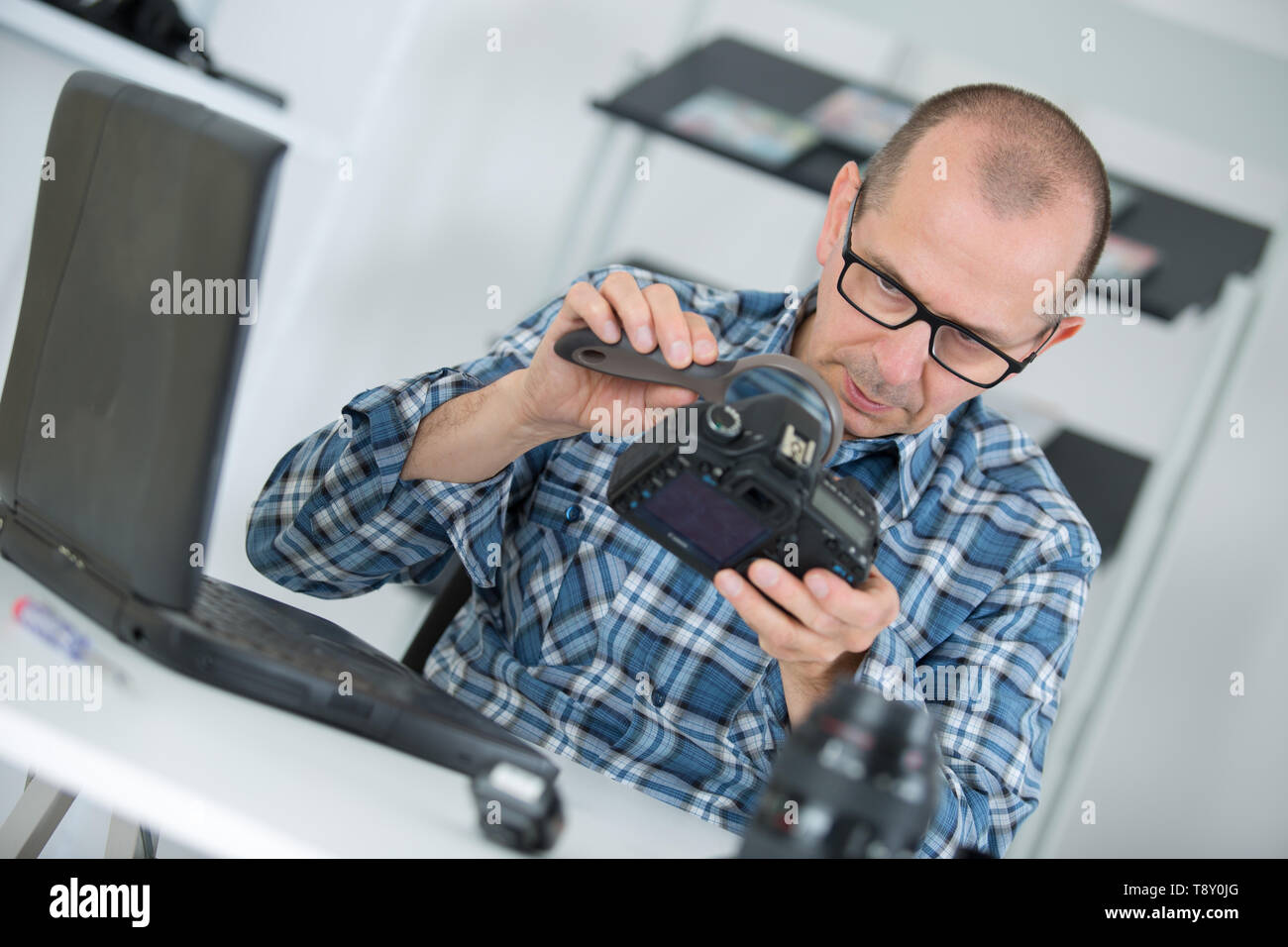 man photographer looking at camera screen Stock Photo - Alamy