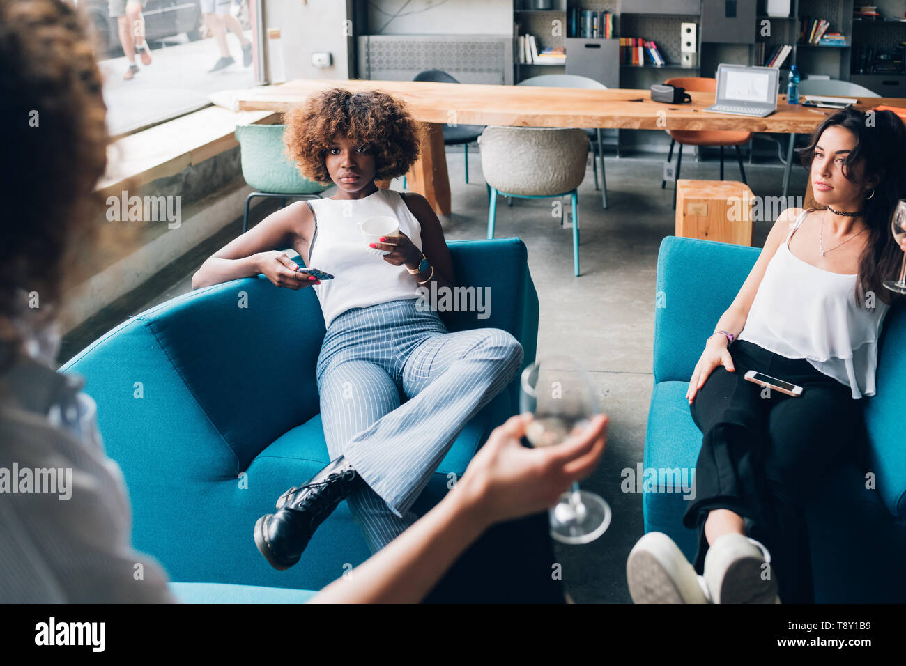 Young women having conversation in a modern office – resourceful ...