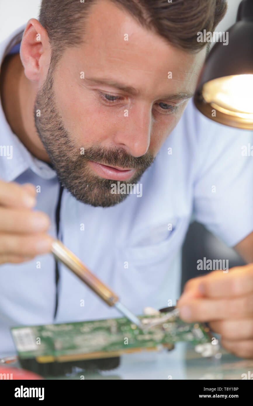 handsome man soldering a circuit board Stock Photo - Alamy