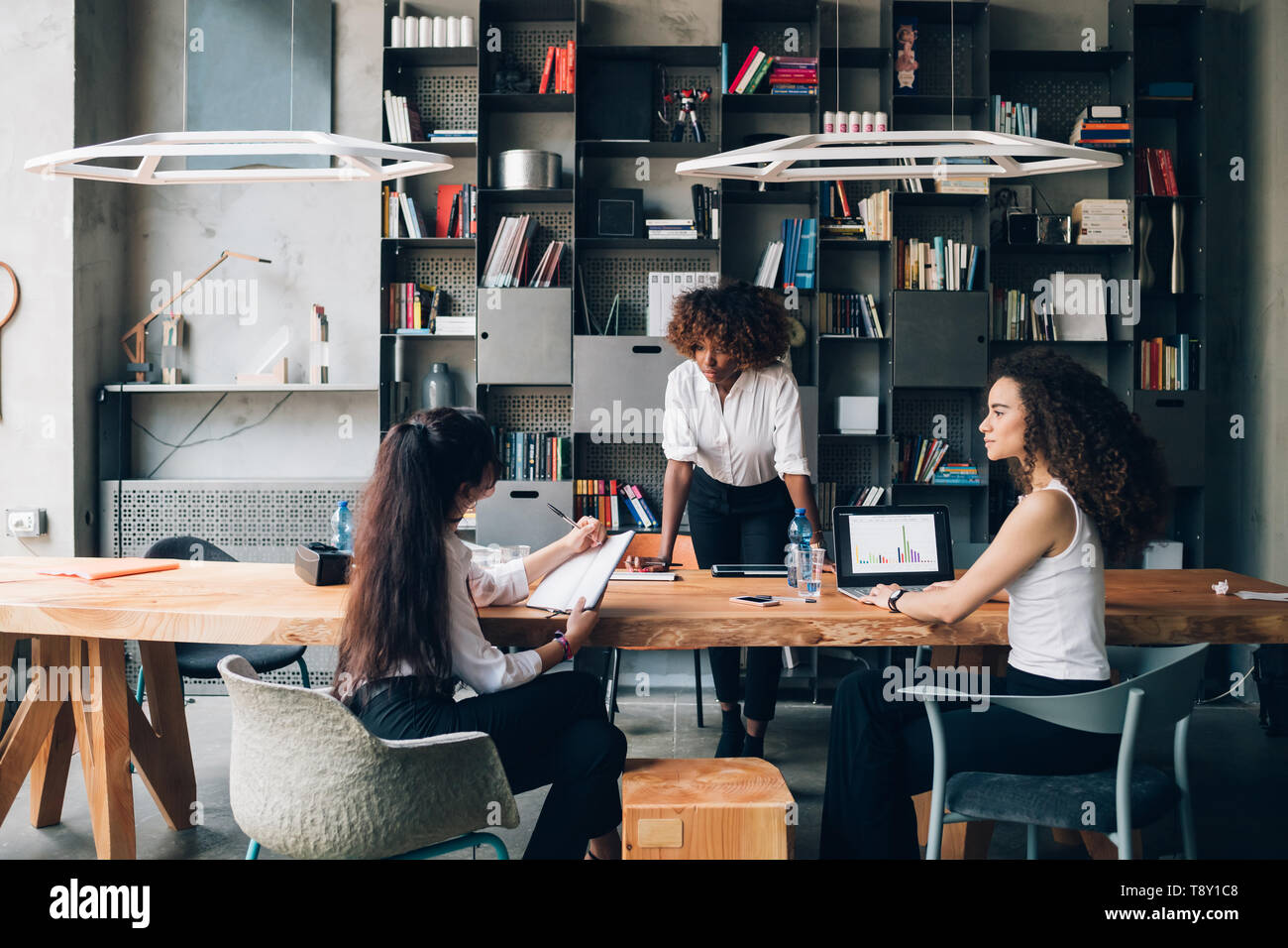 Young women discussing project in coworking space – creativity ...