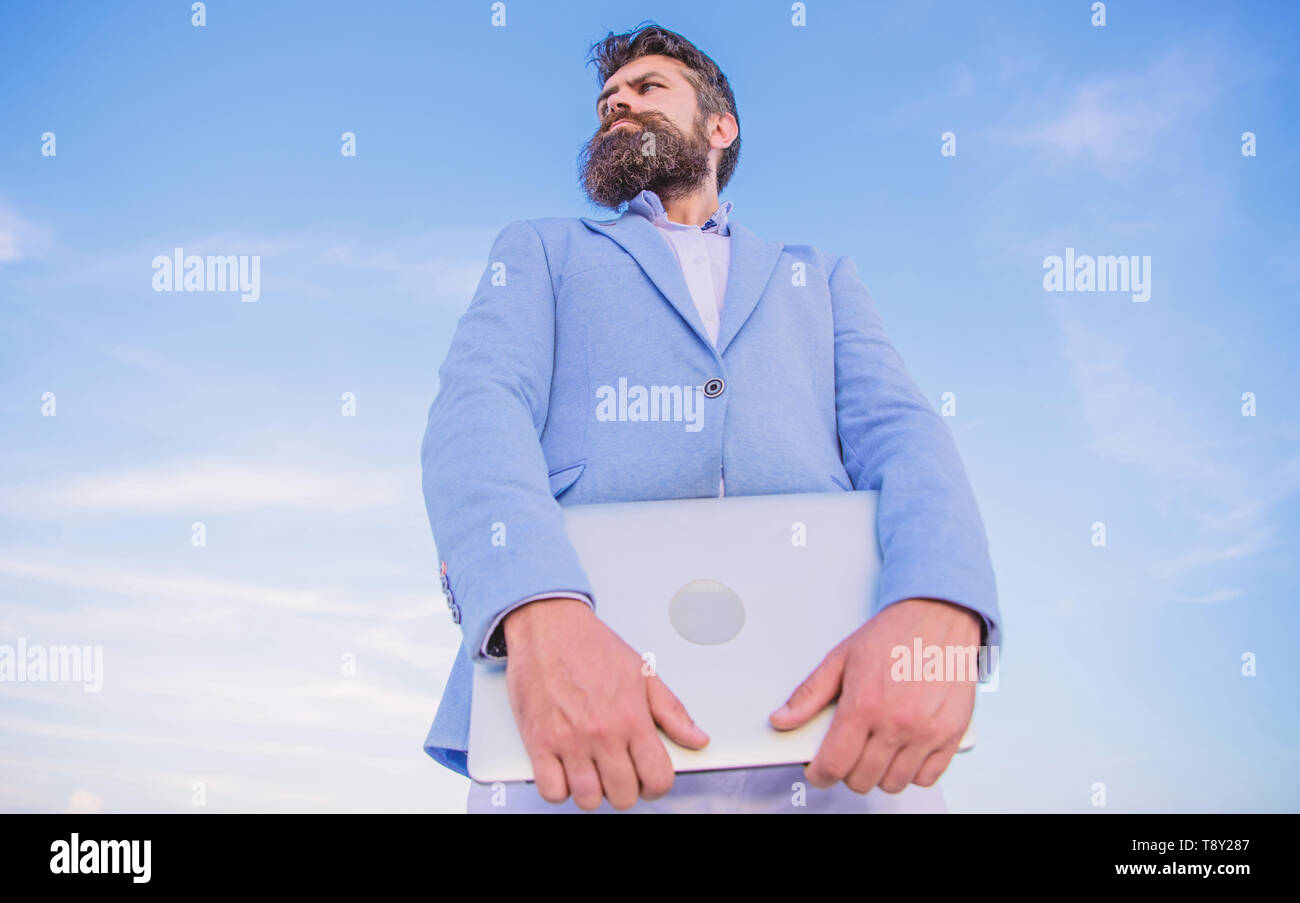 Man bearded hipster manager hold laptop blue sky background. Top ...