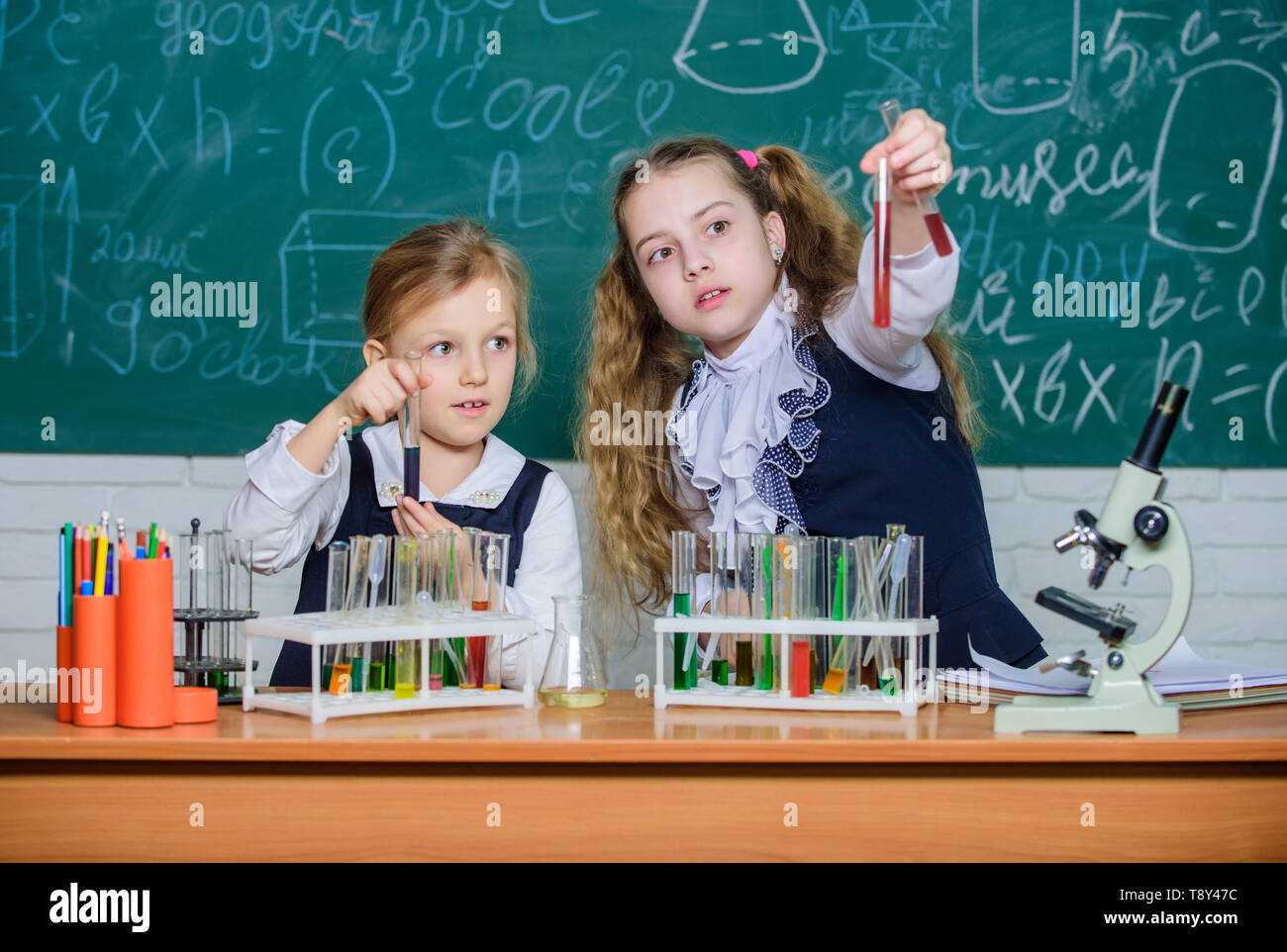 We love science. School children performing experiment in science ...