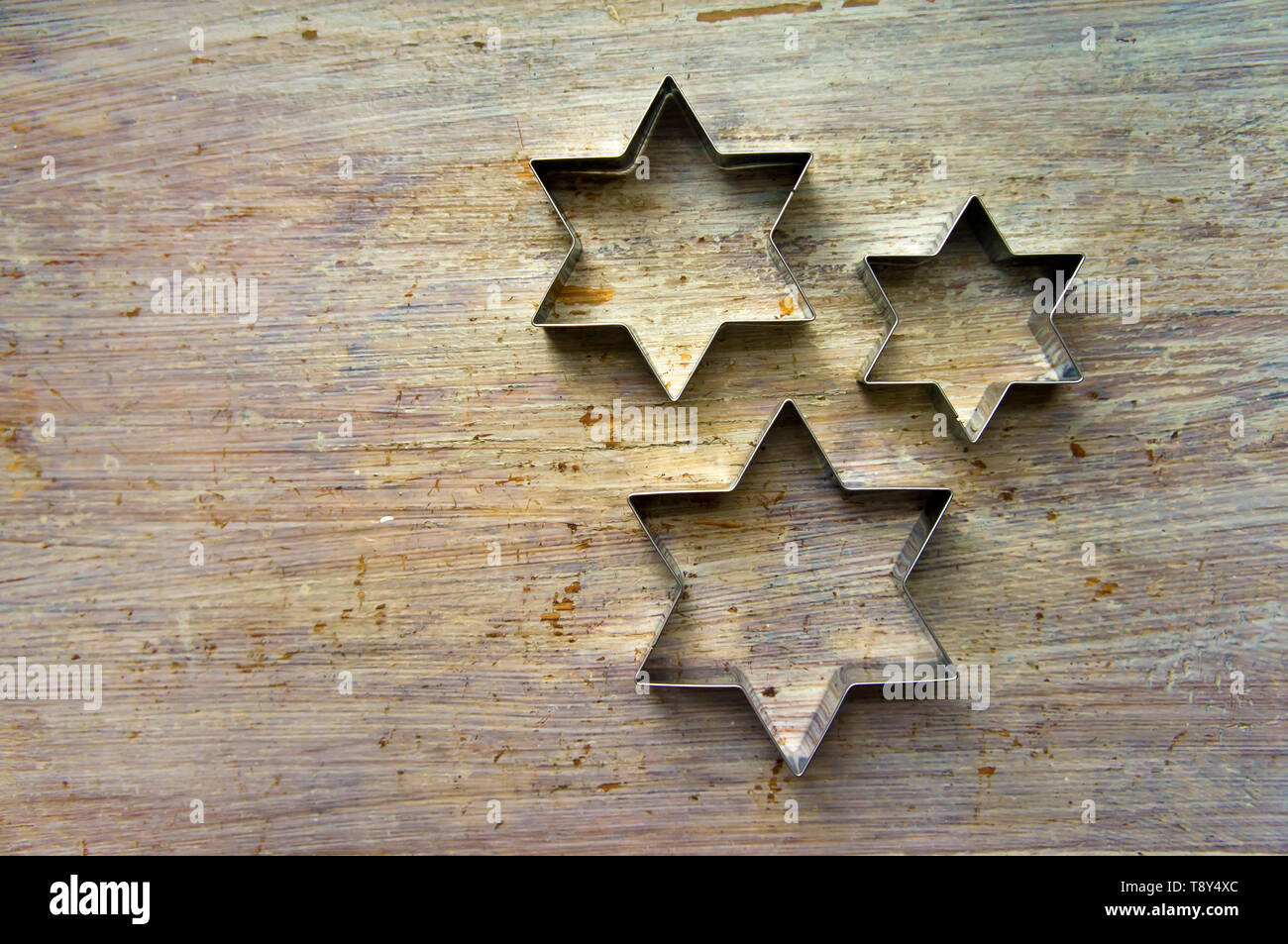 Three metal star shaped pastry cutters on a shabby wood table top Stock ...