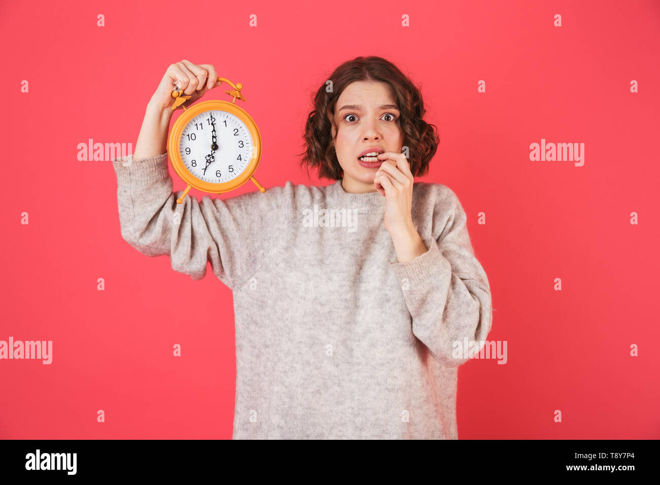 Portrait of a shocked young woman standing isolated over pink ...