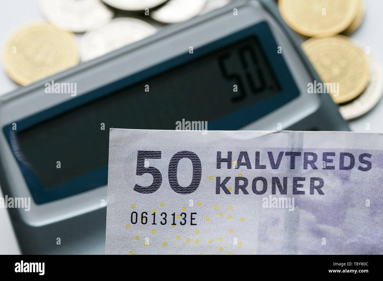 A fifty krone note over a calculator and mixed coins with selective ...