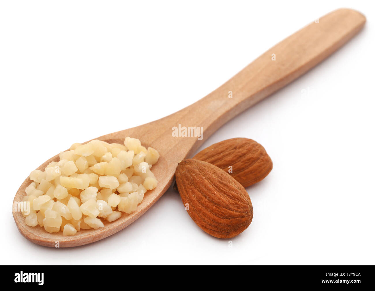 Small pieces of chopped almonds with whole ones over white background ...