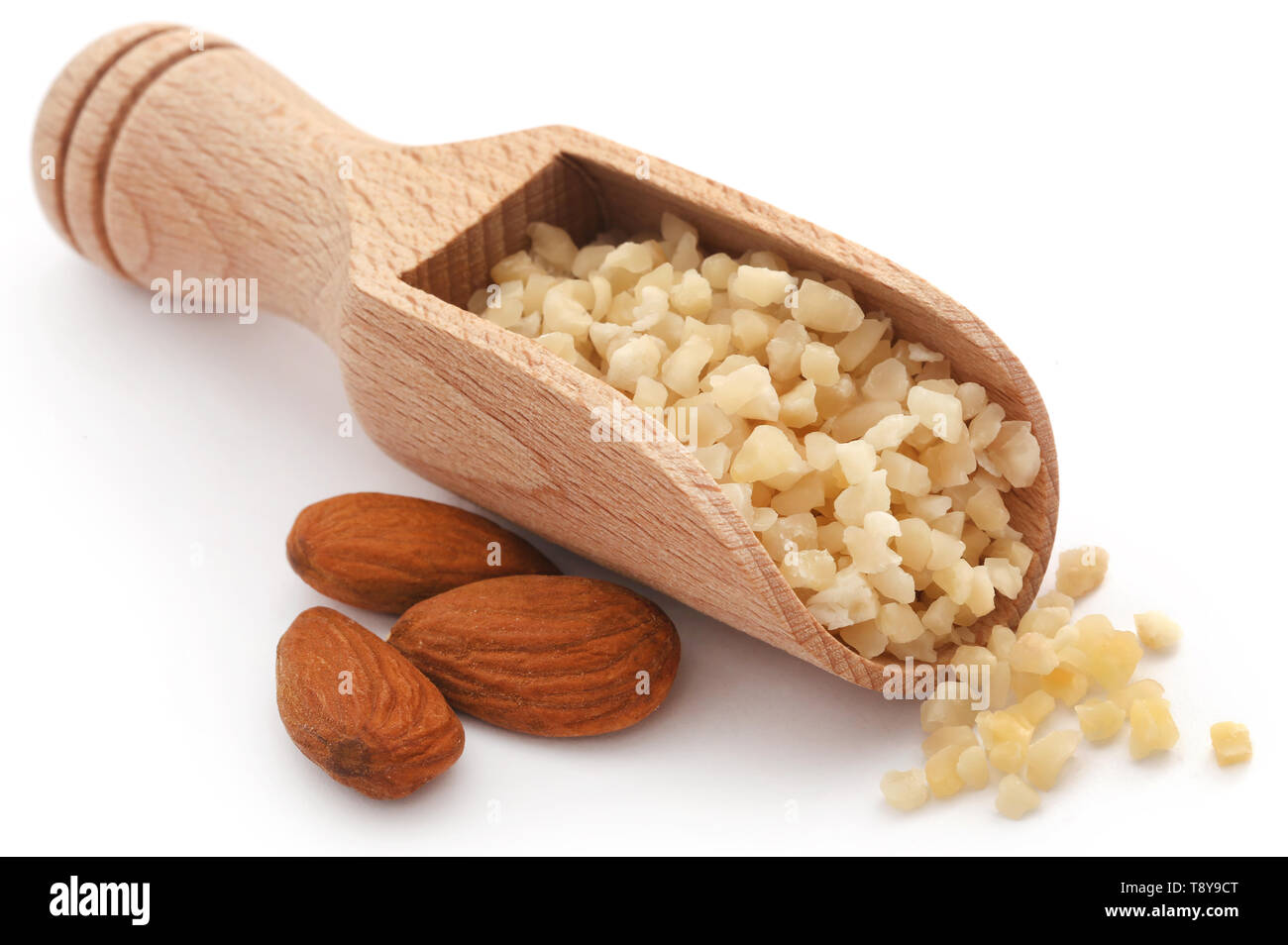 Small pieces of chopped almonds with whole ones over white background ...