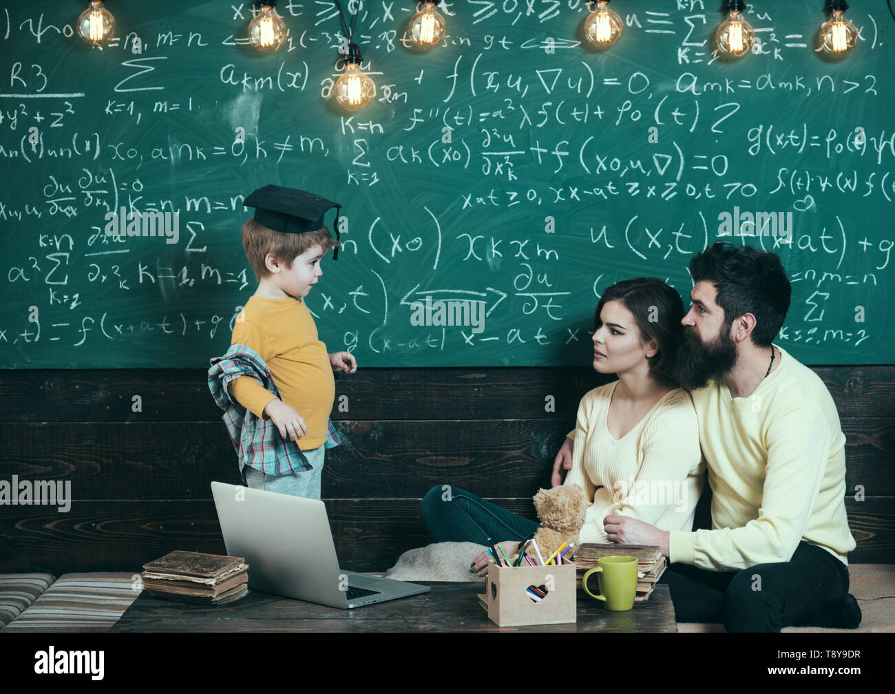 Parents listening their son, chalkboard on background. Homeschooling ...