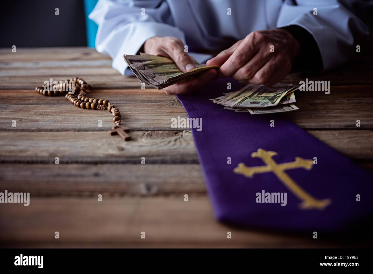 Priest counting money in his hand. Church and money Stock Photo - Alamy