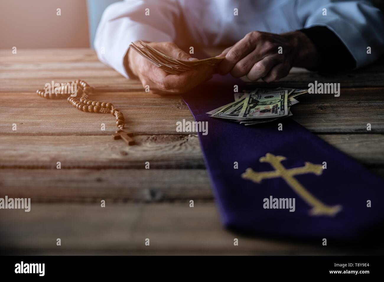 Priest counting money in his hand. Church and money Stock Photo - Alamy