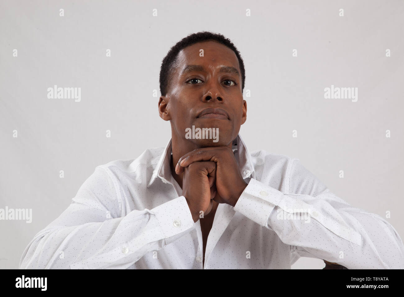 Man folded hands sitting hi-res stock photography and images - Alamy