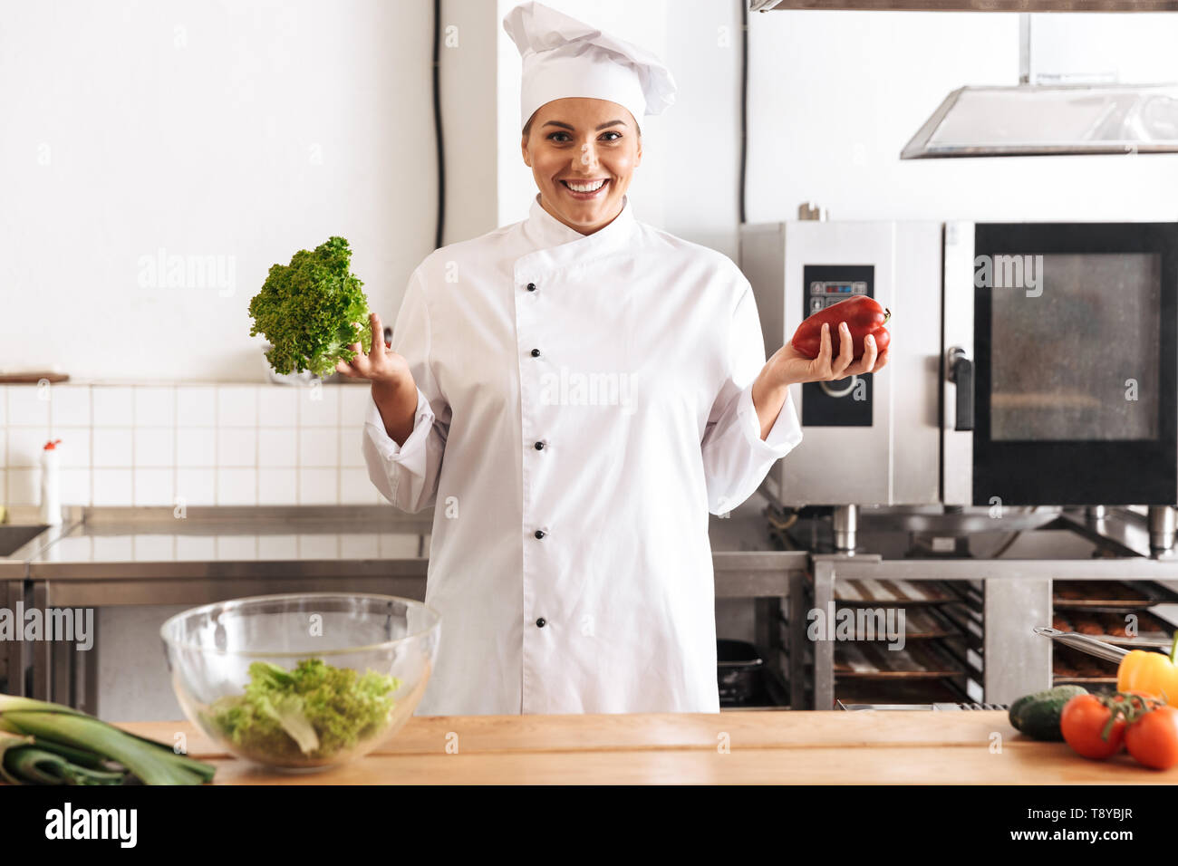 Photo of beautiful woman chef wearing white uniform cooking meal with ...