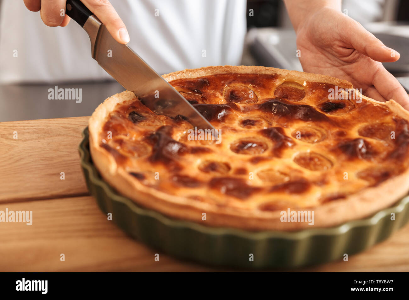 Image of professional woman chef wearing white uniform cutting apple ...