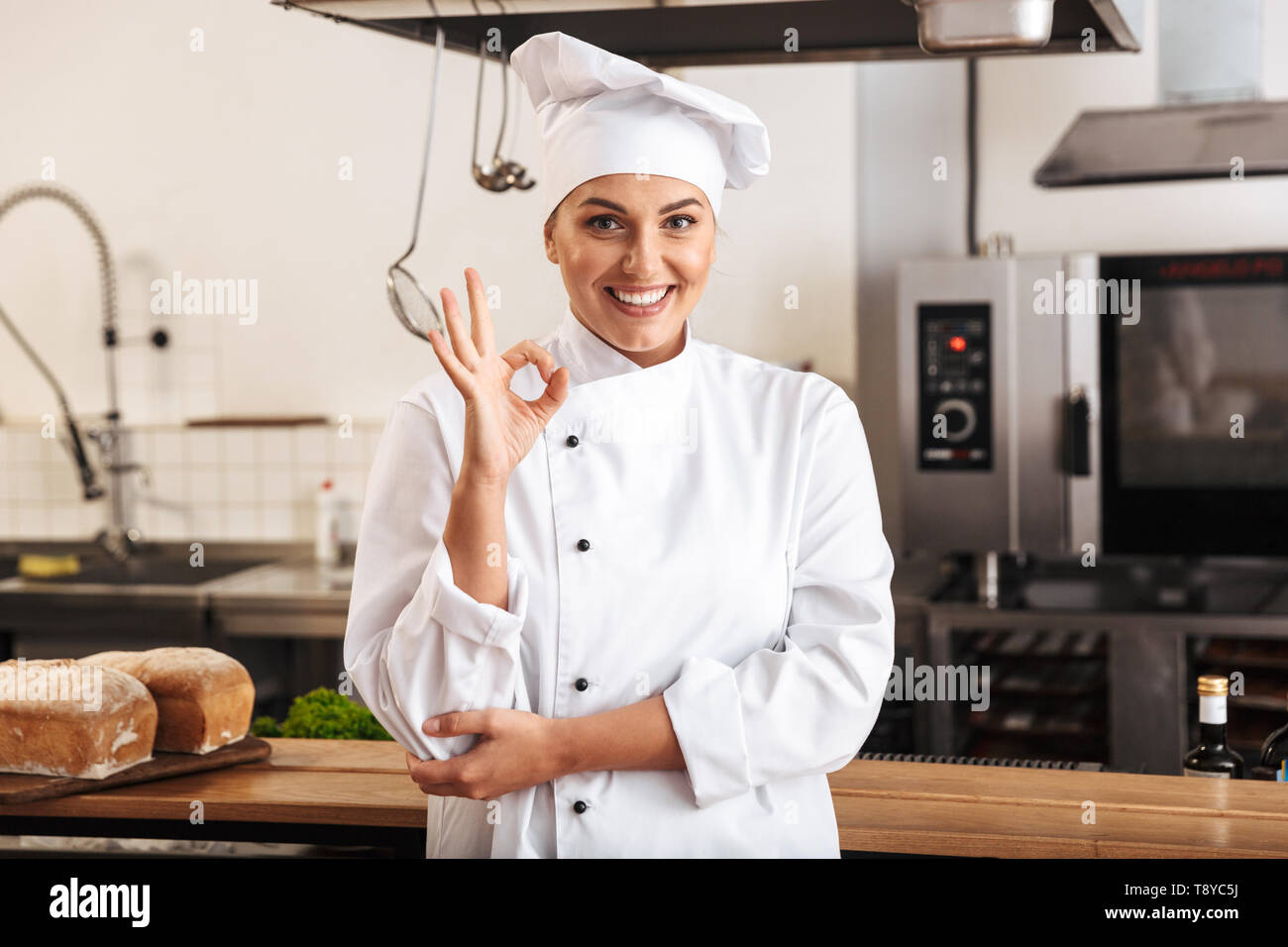 Portrait of caucasian woman chef wearing white uniform posing in ...