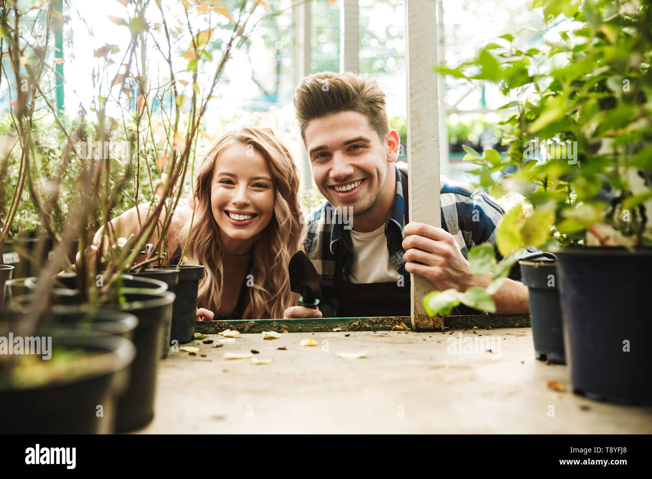 Image of two amazing gardeners posing in the nature greenhouse garden ...