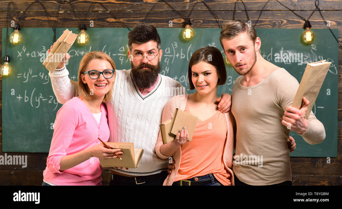 Happy young university students studying with books in classroom. Group ...