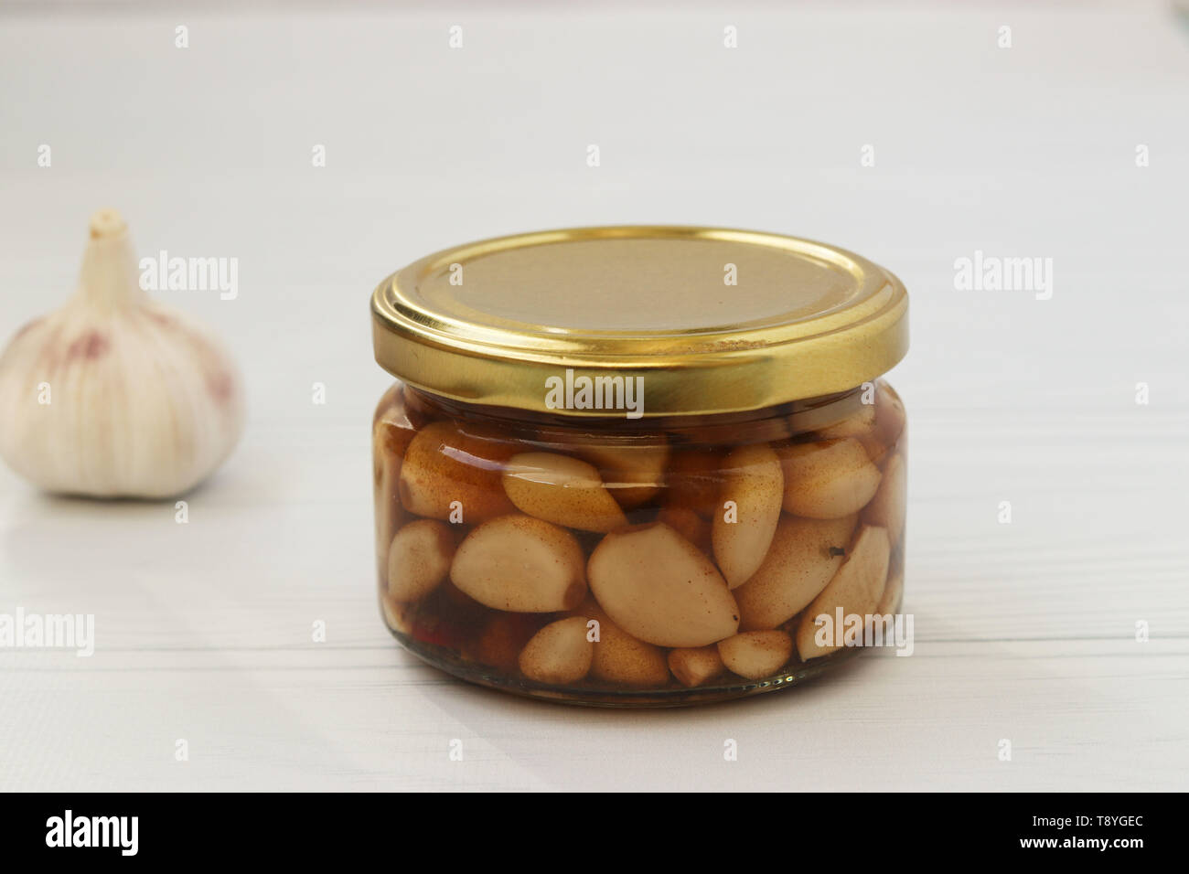 Marinated garlic in a jar on a white background Stock Photo - Alamy