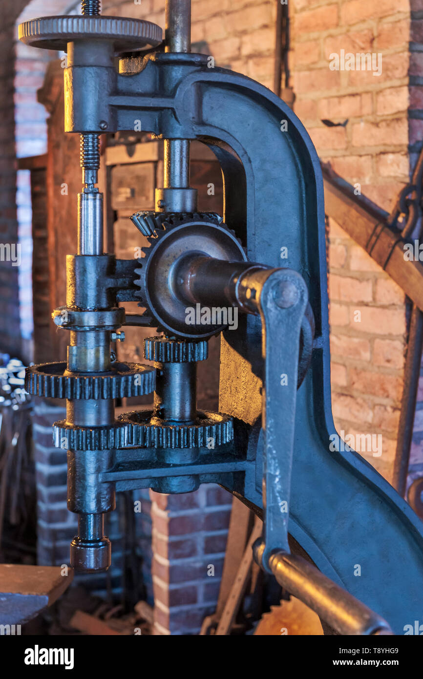 Old-fashioned drill with hand drive and reduction gear in an abandoned ...