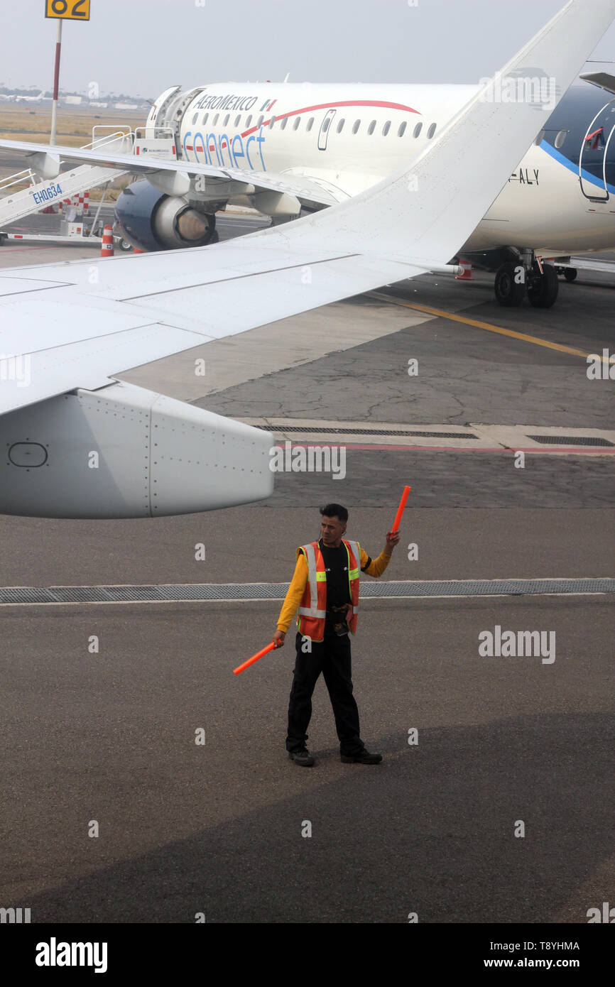 Signal man guiding airplane. Mexico City airport Stock Photo - Alamy