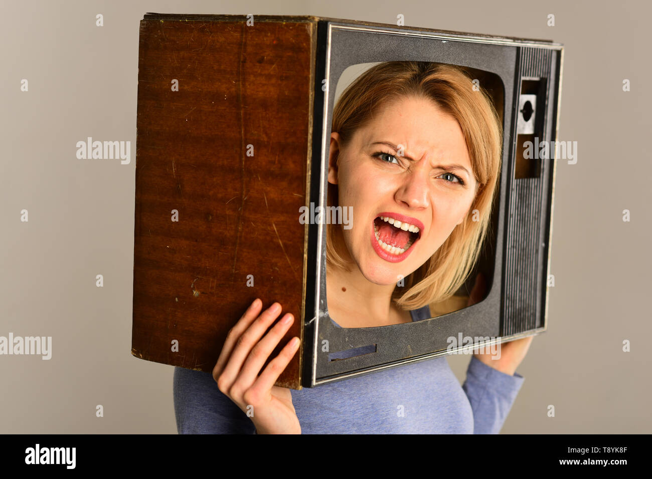 television set. television set on head of angry woman. woman hold ...