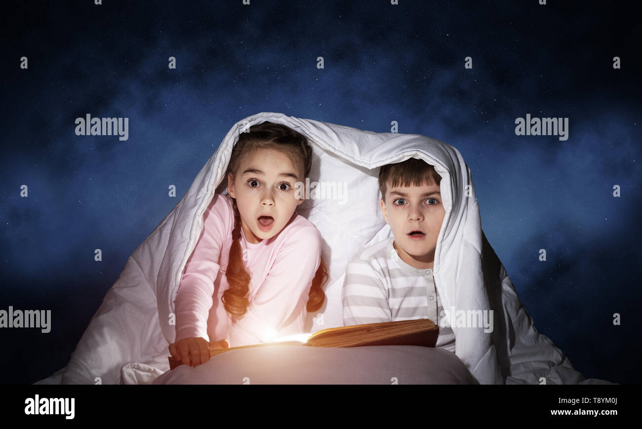 Children reading scary stories in bed Stock Photo - Alamy