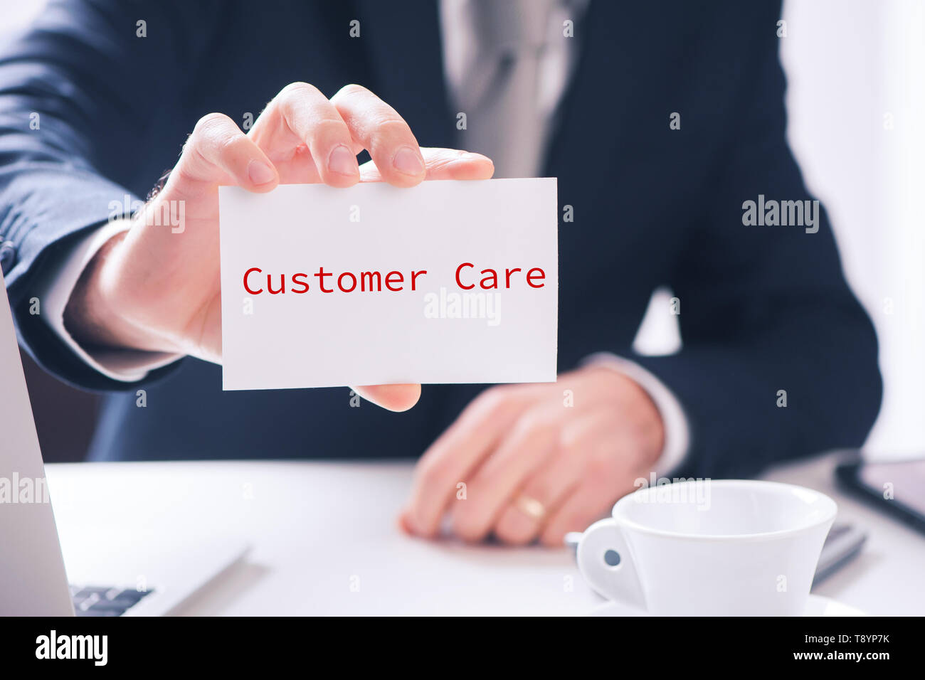A closeup of businessman holding white card with Customer care sign ...