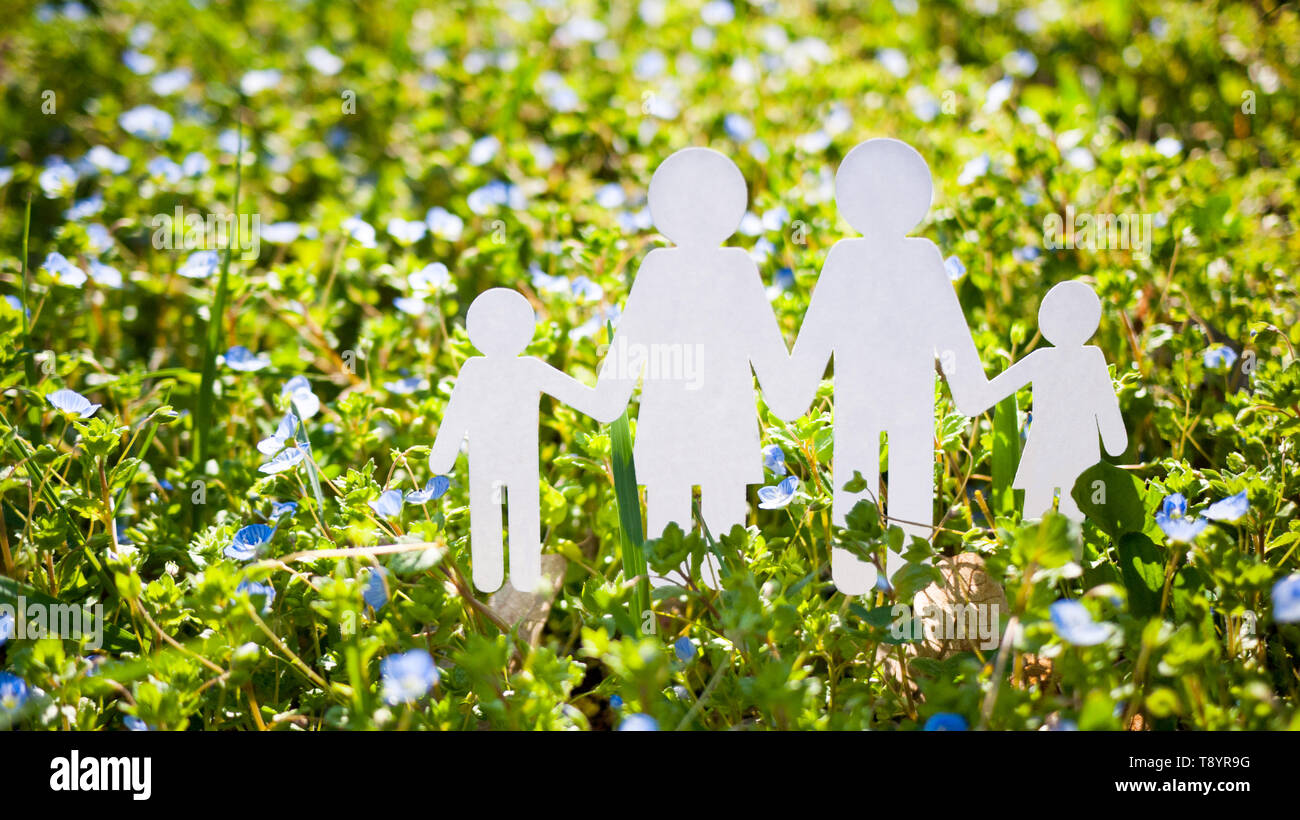 Paper cut family on green grass background Stock Photo - Alamy