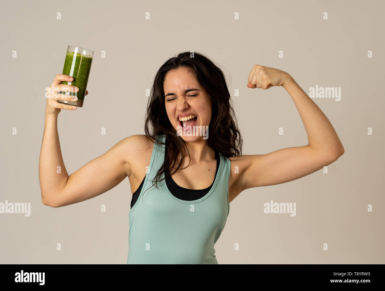 Fitness woman happy smiling holding glass of green vegetable smoothie ...