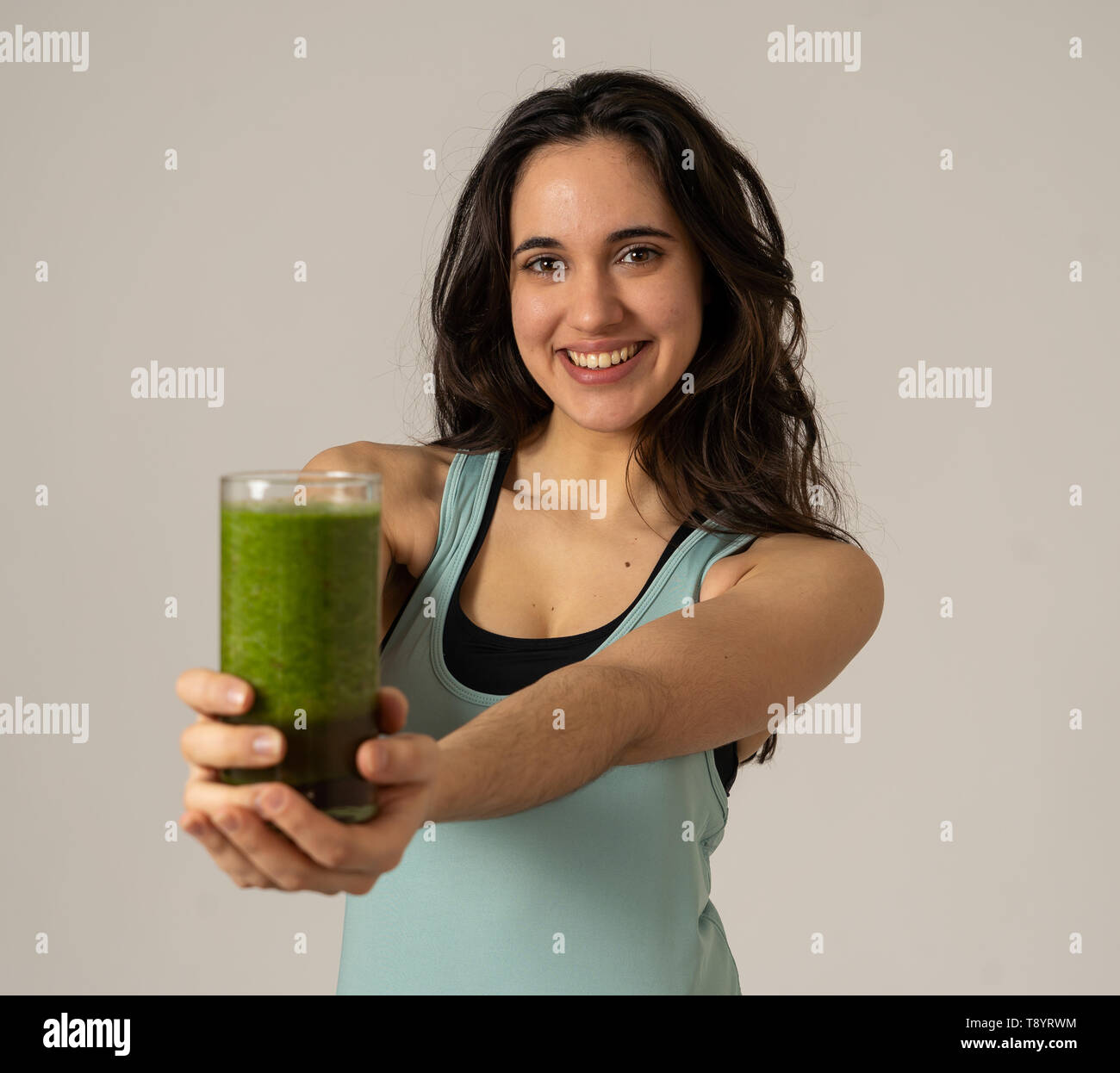 Fitness woman happy smiling holding glass of green vegetable smoothie ...