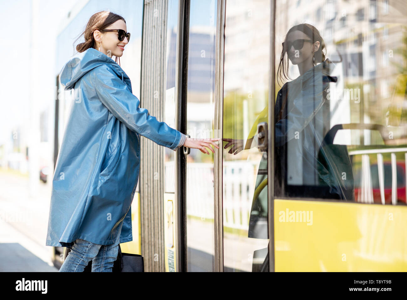 Woman entering the door of the modern tram at the station Stock Photo ...