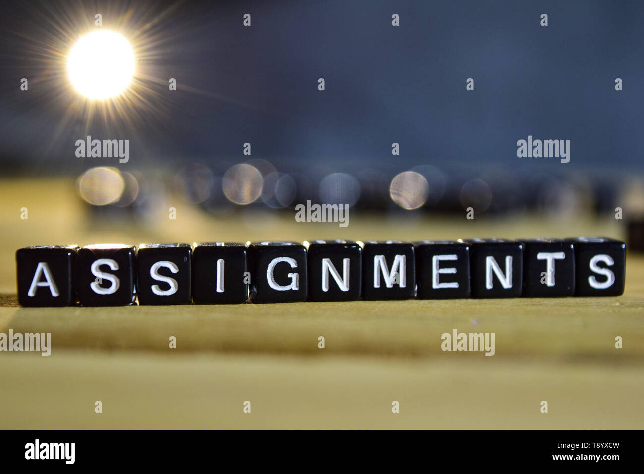 ASSIGNMENTS concept wooden blocks on the table. With personal ...