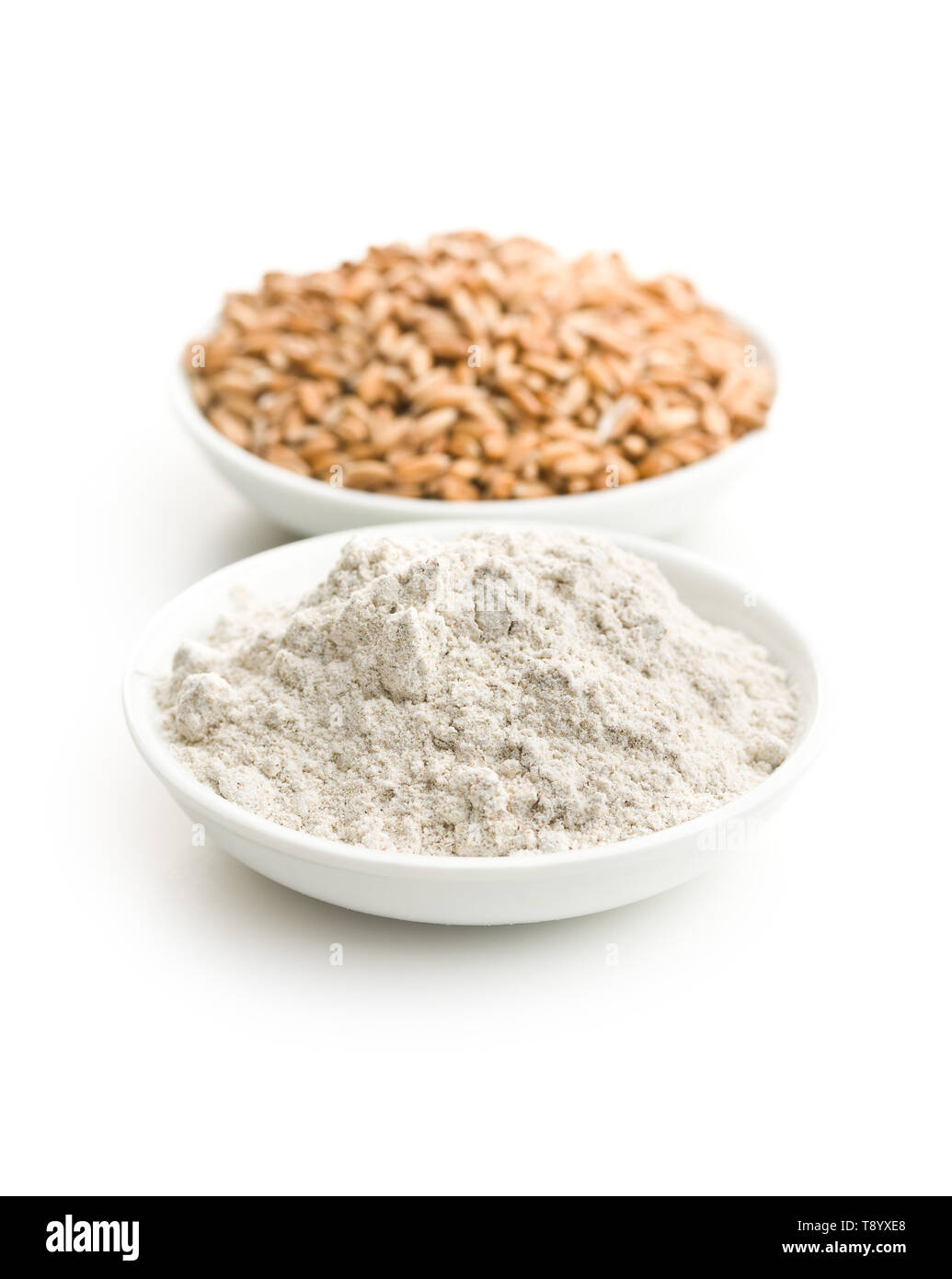 Whole grain wheat flour and wheat grains in bowl isolated on white ...