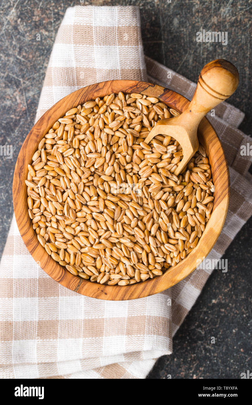 Healthy spelt grains in wooden bowl Stock Photo - Alamy