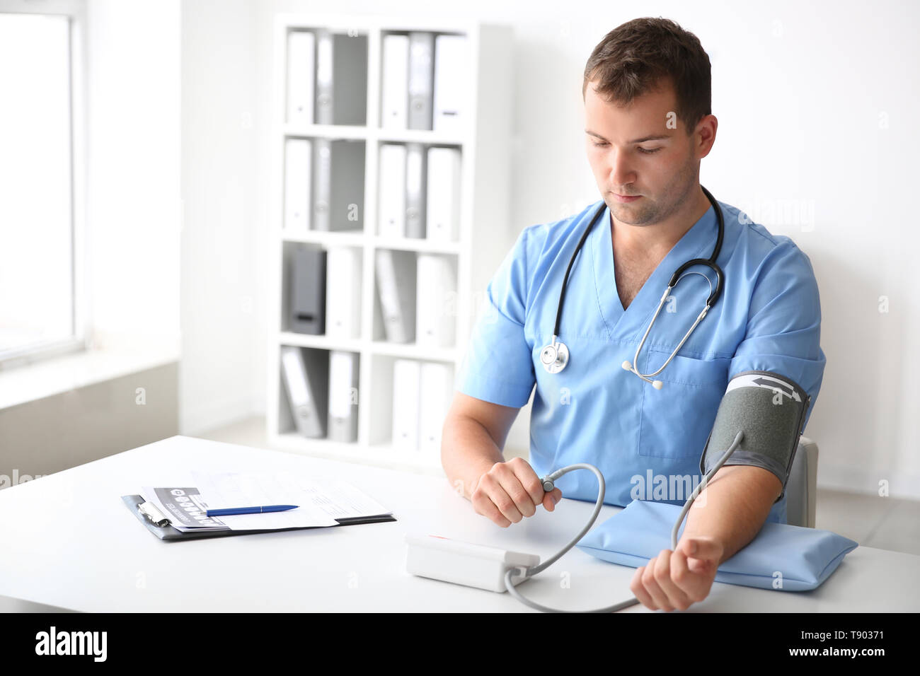 Male doctor measuring his blood pressure in hospital Stock Photo - Alamy