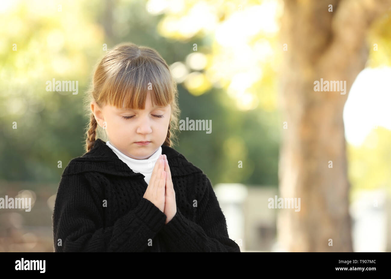 Little girl praying outdoors Stock Photo - Alamy