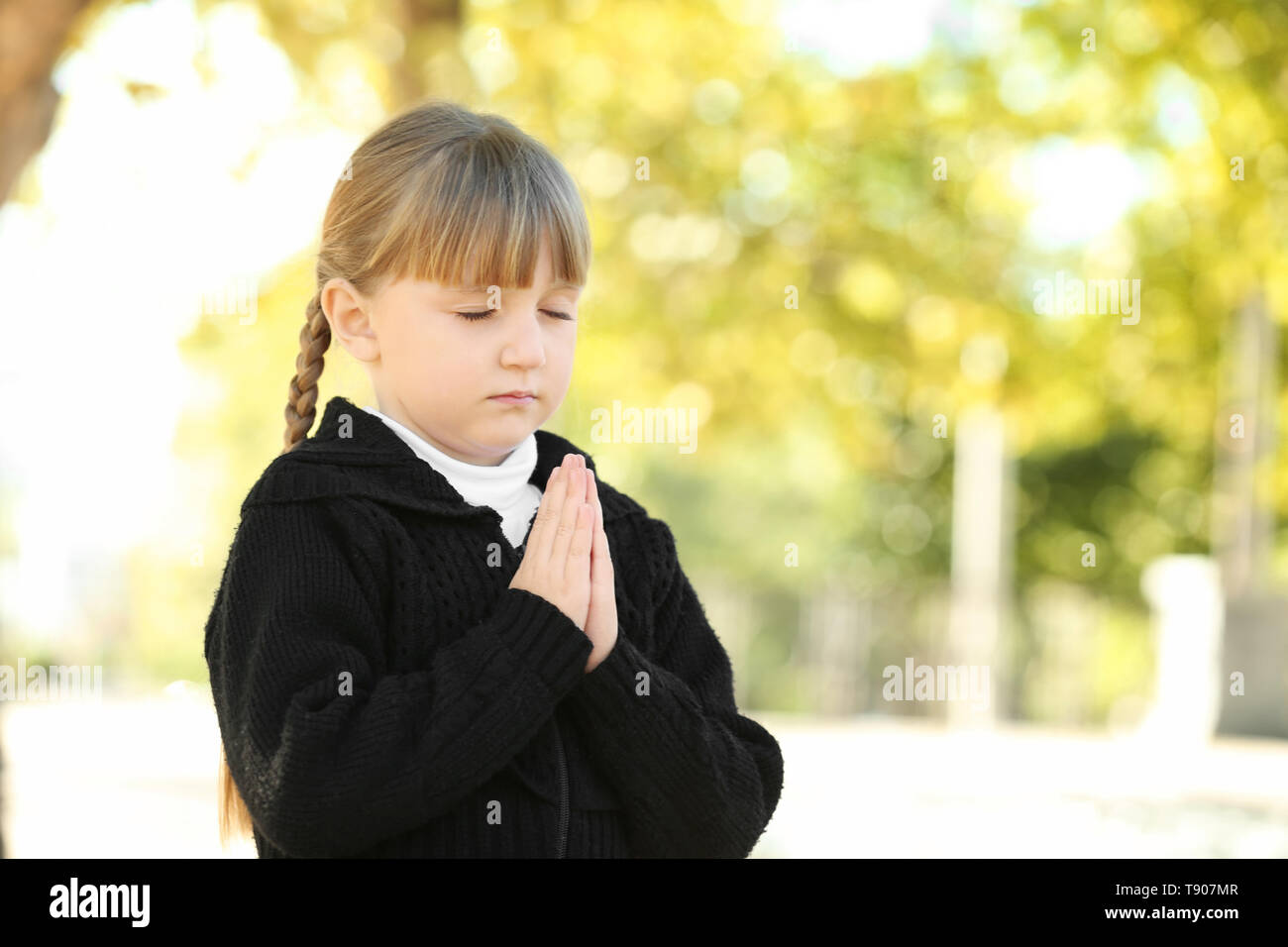 Little girl praying outdoors Stock Photo - Alamy