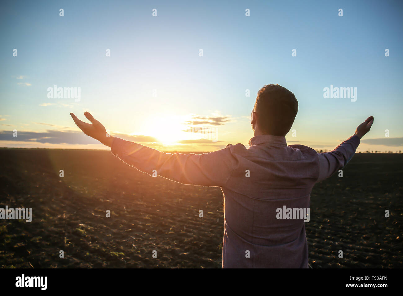 Religious man praying outdoors at sunset Stock Photo - Alamy