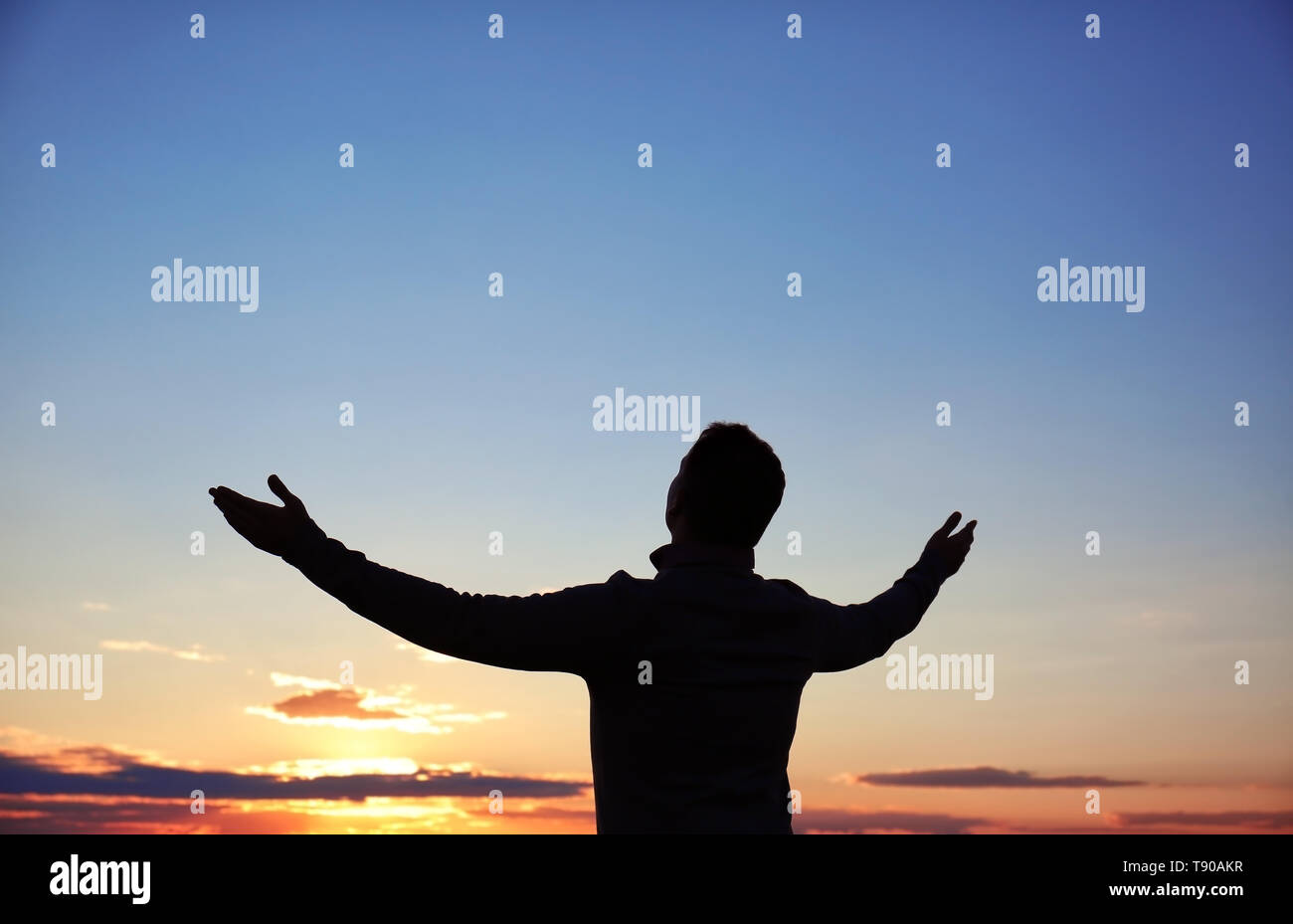 Religious man praying outdoors at sunset Stock Photo - Alamy